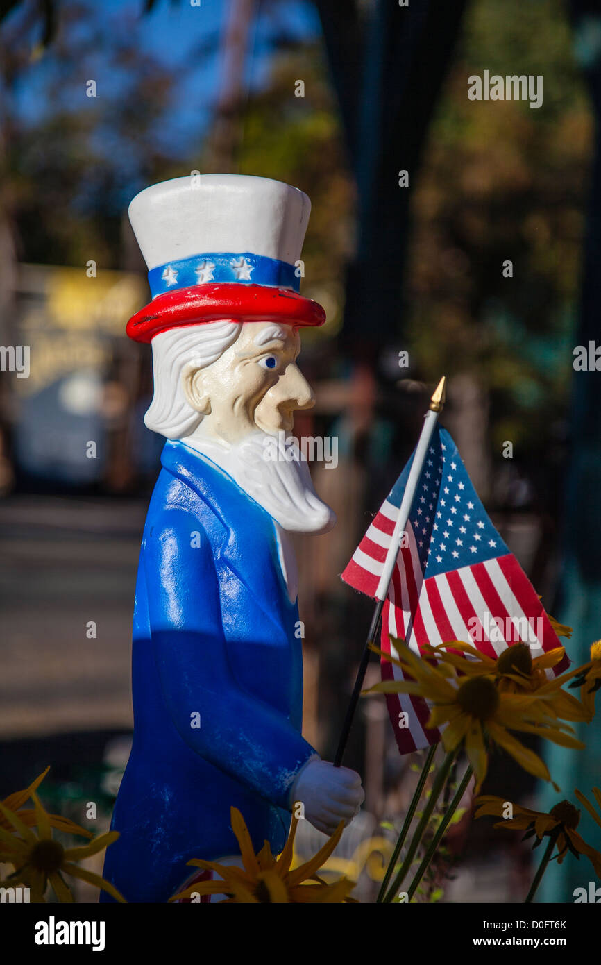 Statue of Uncle Sam holding American Flag and wearing red, white and ...