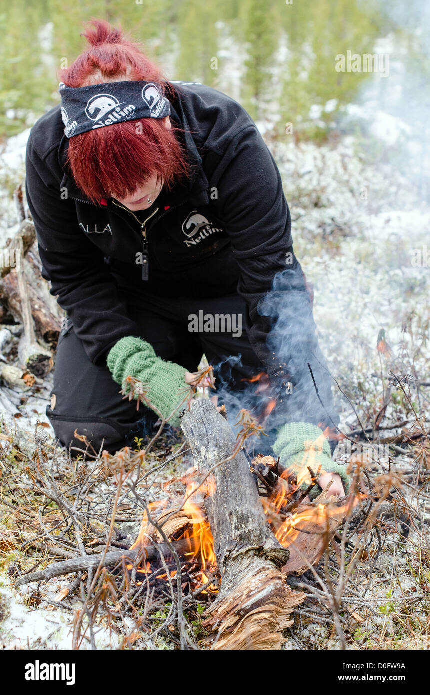 Girl lighting a fire for barbecue Lapland Finland Scandinavia Stock ...