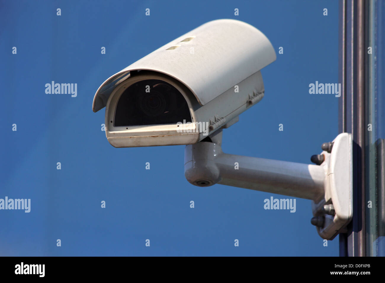 white cctv security camera on blue background Stock Photo - Alamy