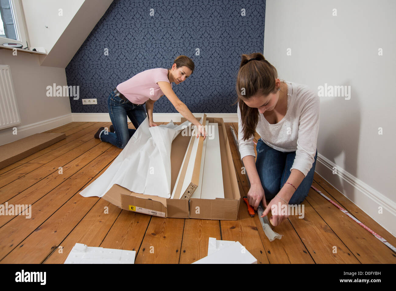 Mother and daughter assemble furniture, bed. Do it yourself. Home ...