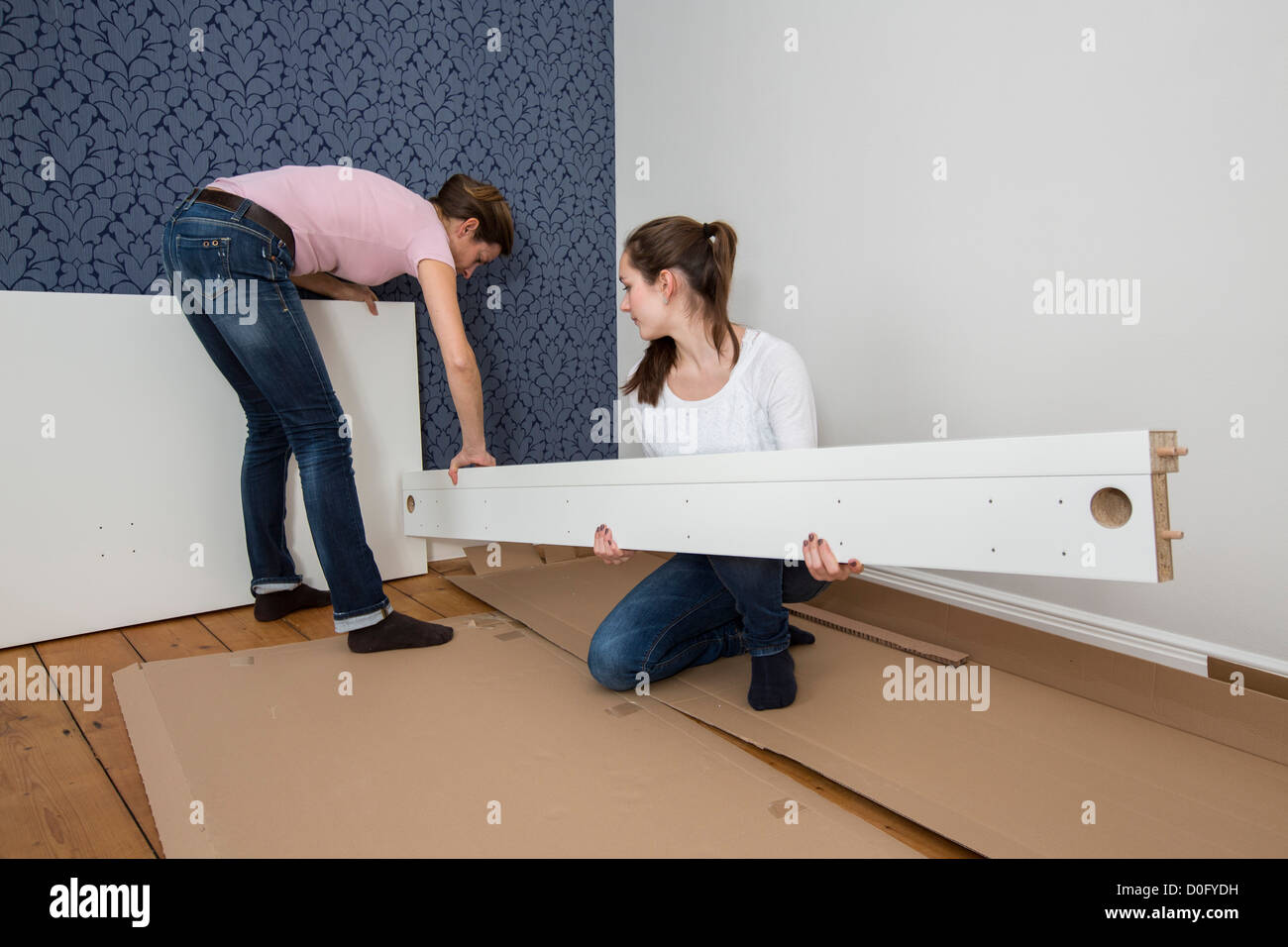 Mother and daughter assemble furniture, bed. Do it yourself. Home ...
