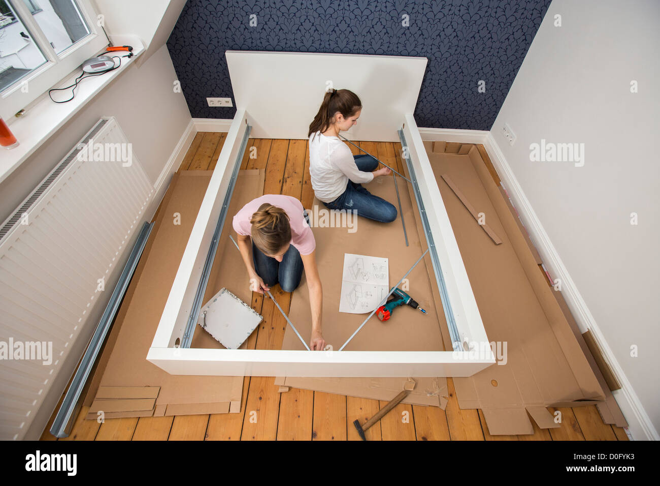 Mother and daughter assemble furniture, bed. Do it yourself. Home ...