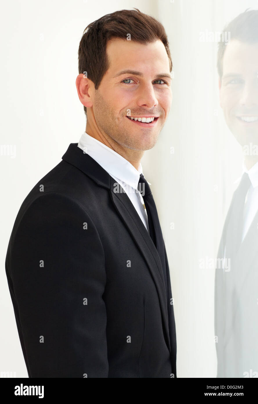 Young and attractive male smiles at the camera while wearing a suit ...