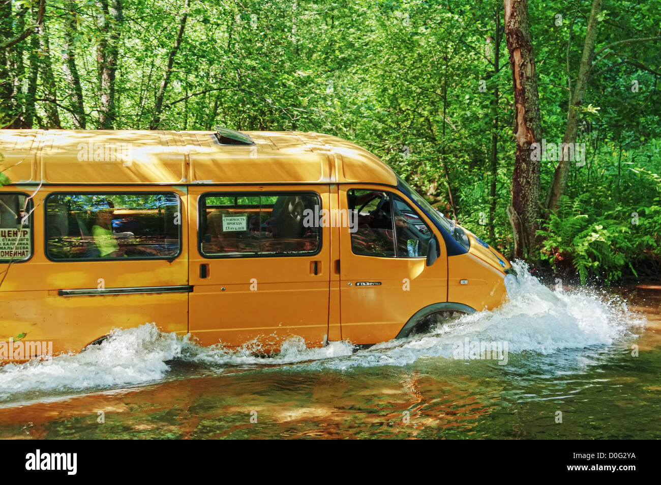 Yellow minibus fording small river Stock Photo - Alamy
