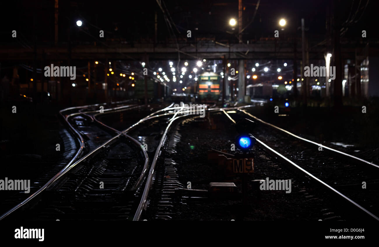 Railroad night scene with blue traffic light and cargo trains ...