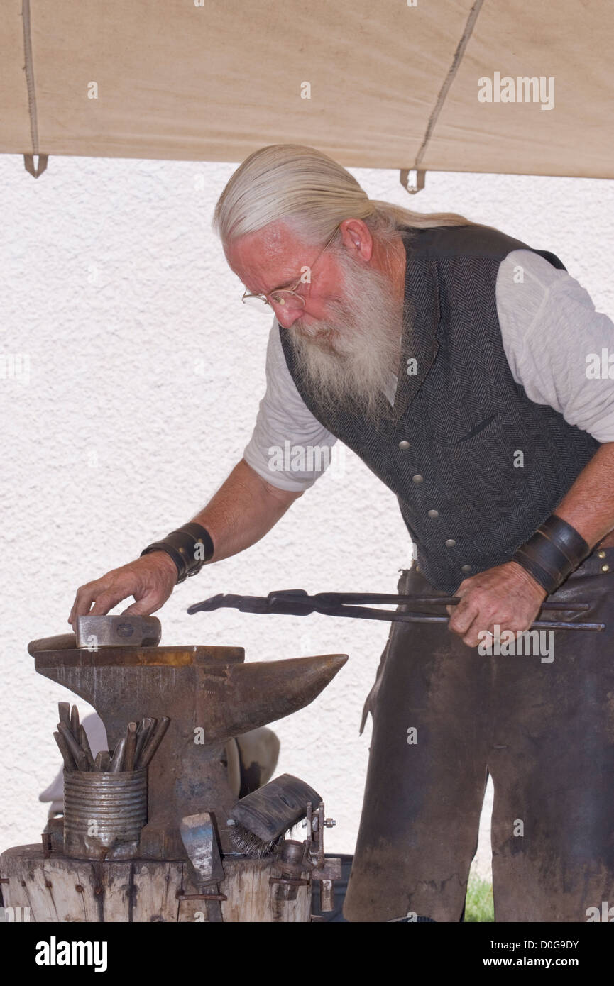 A blacksmith hammers away on his anvil, making horseshoes in Lincoln ...