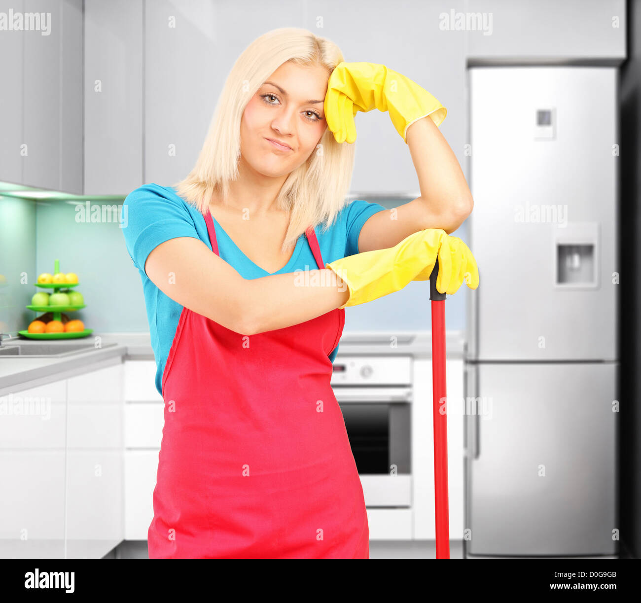 A tired female cleaner resting after cleaning a kitchen Stock Photo - Alamy