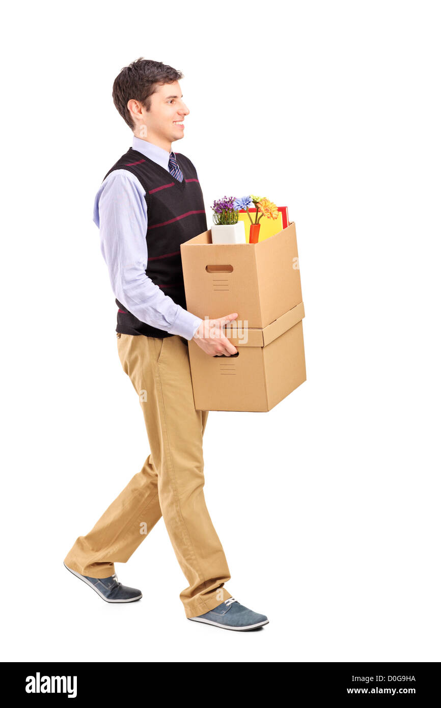 Full length portrait of a smiling male walking with boxes, moving into ...