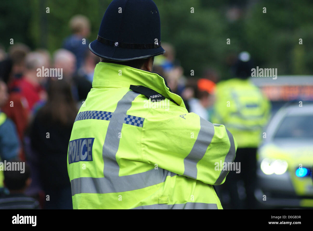 Police officer looking at police officer, police car and crowd Stock ...