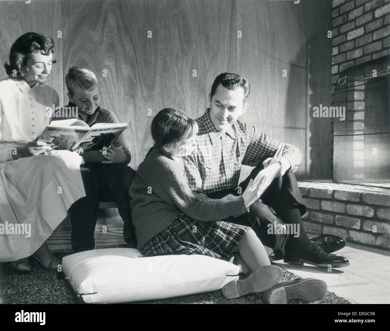Family reading by the fire Stock Photo - Alamy