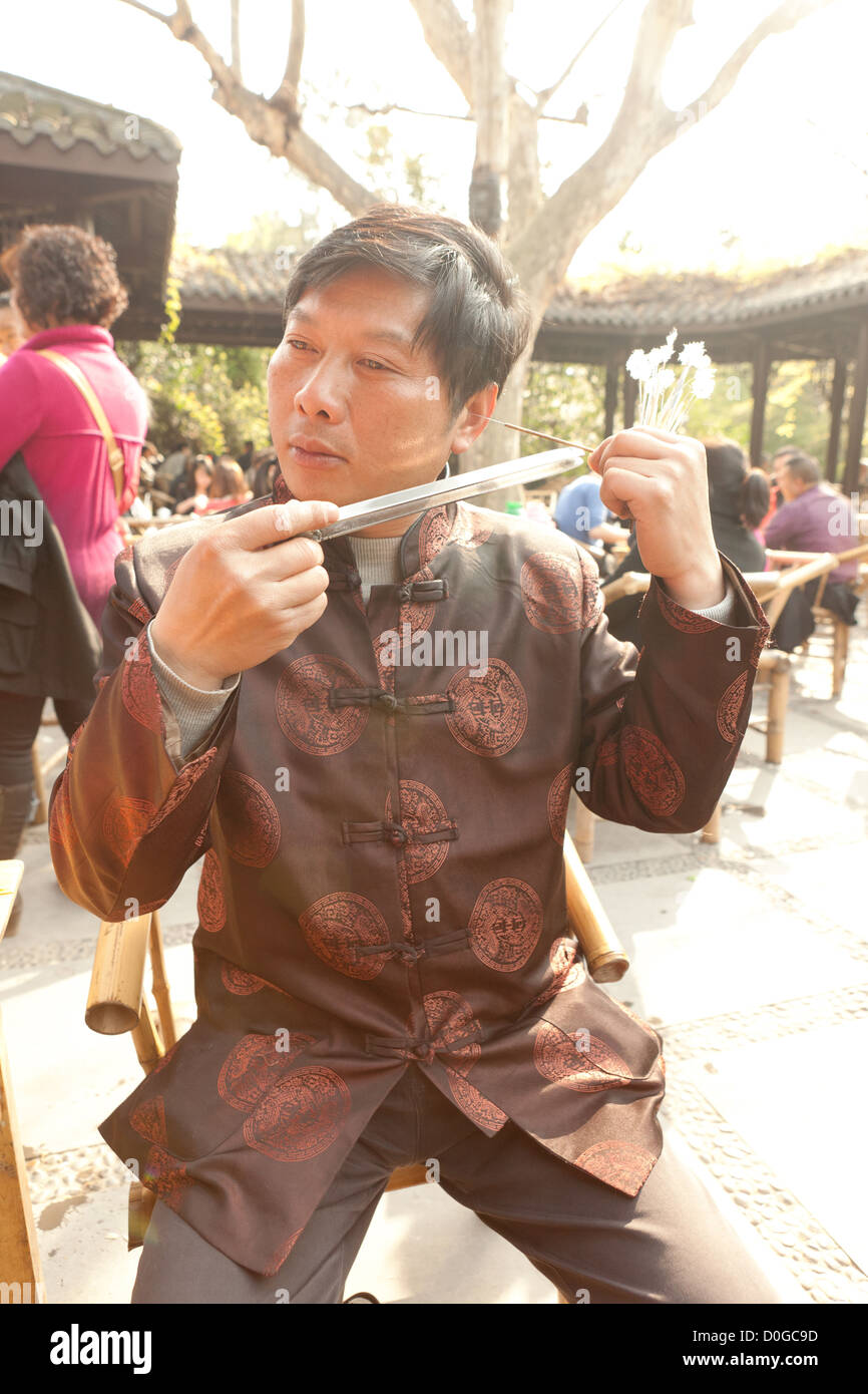 An Ear Cleaner offers his services at Renmen Park Teahouse, in Chengdu ...