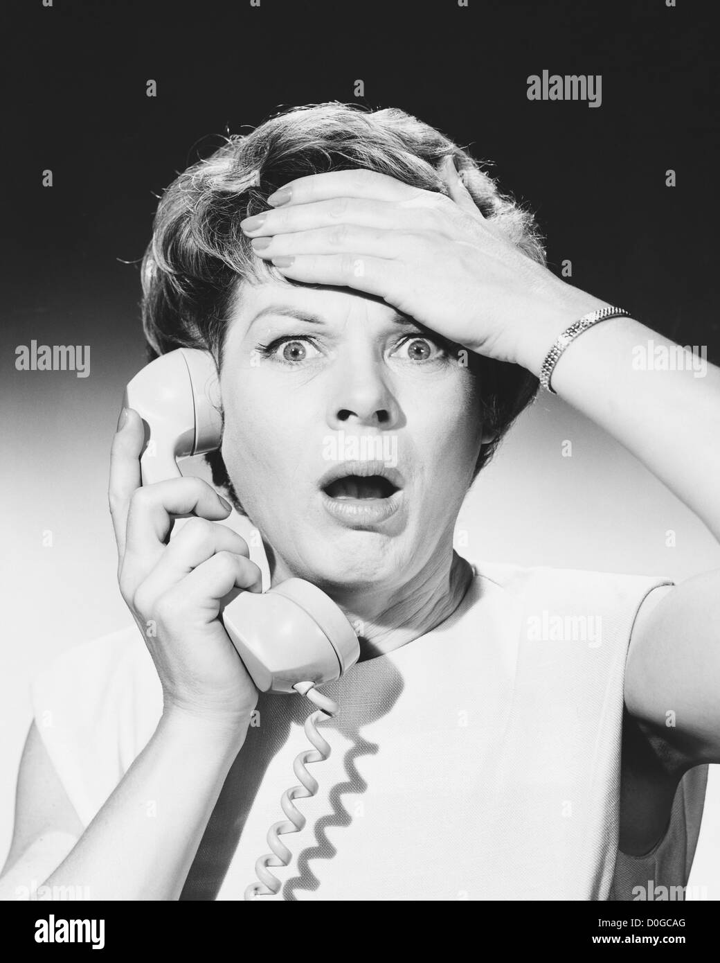 Shocked woman on telephone Stock Photo - Alamy