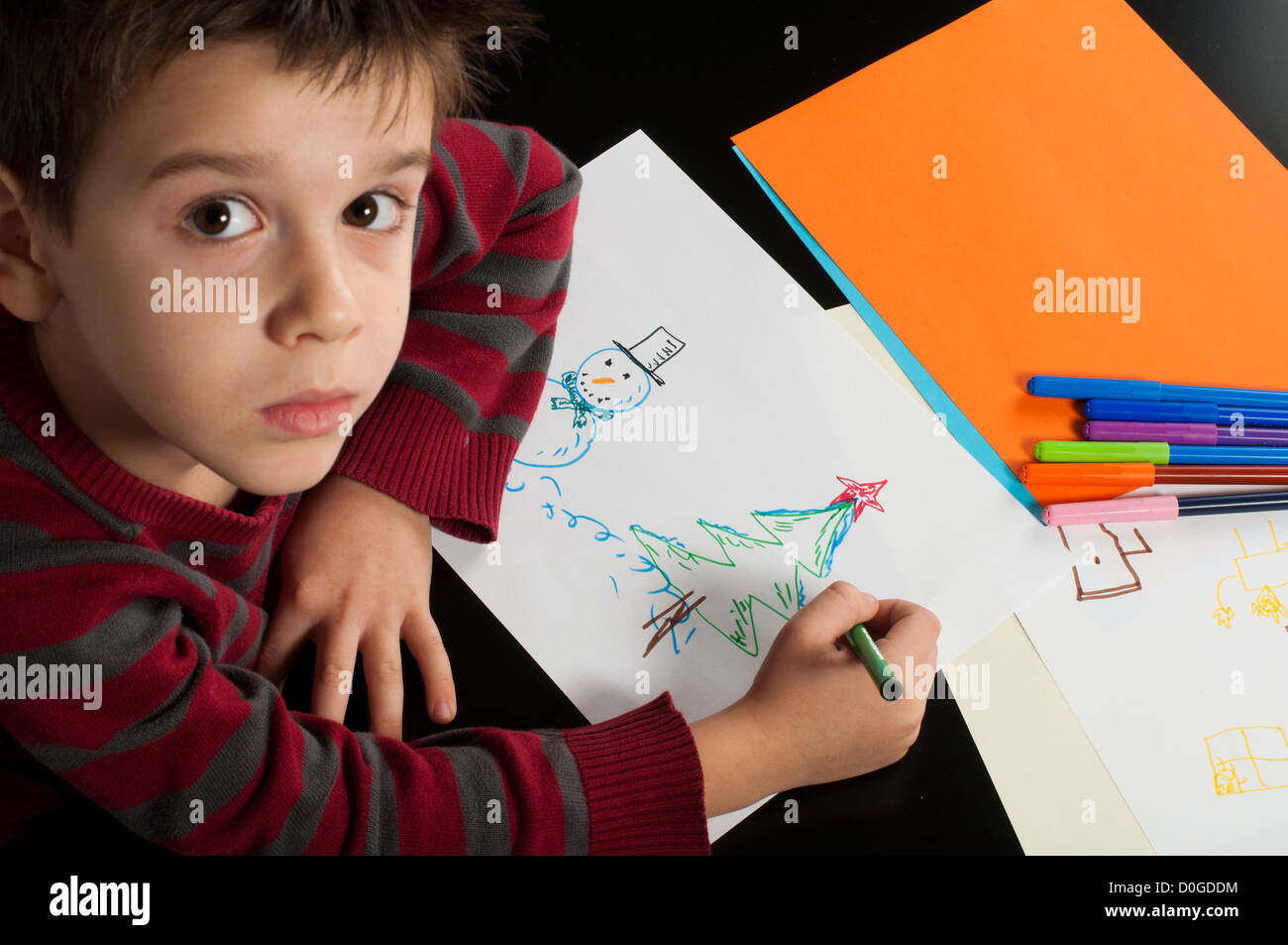Boy drawing with markers. Multicolored papers Stock Photo - Alamy