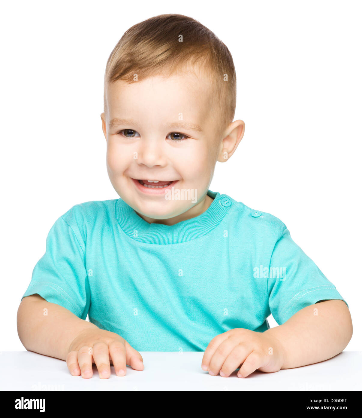 Portrait of a cute little boy sitting at table, isolated over white ...