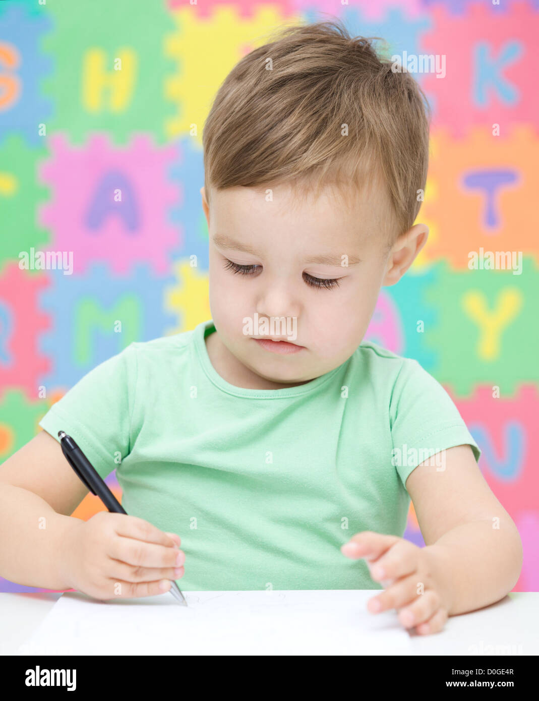Little boy is writing on his copybook in preschool Stock Photo - Alamy