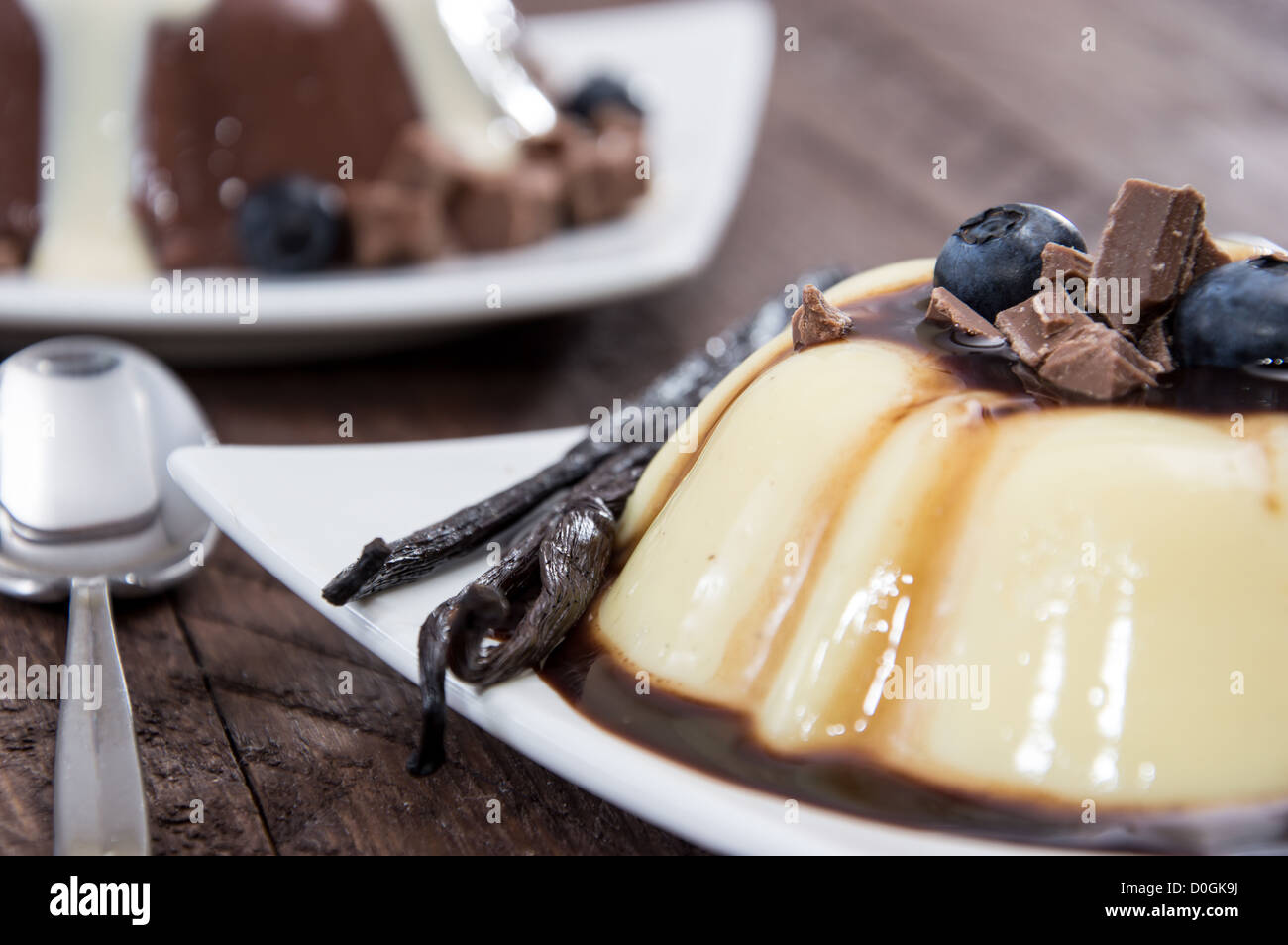 Different sorts of Pudding topped with sauces on wooden background ...