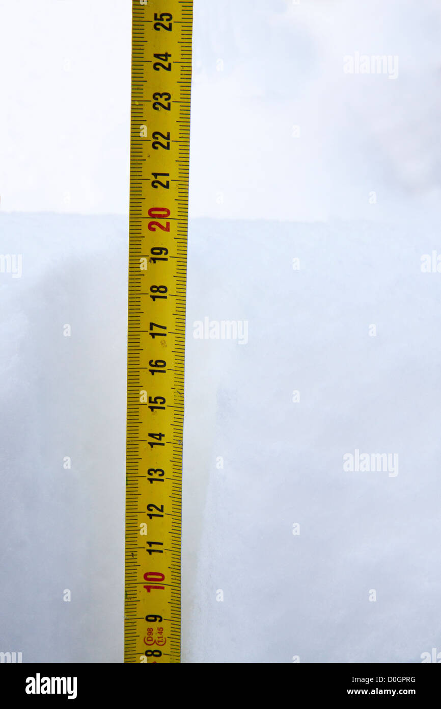 Measuring the snow level with spring rule Stock Photo - Alamy