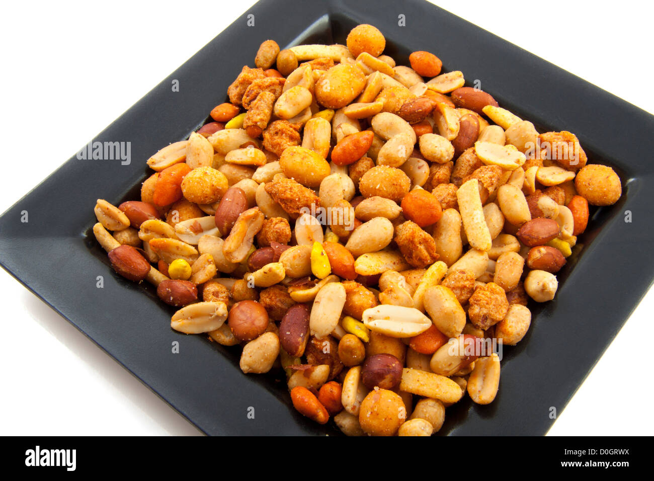 Different kind of peanuts on a black plate Stock Photo - Alamy