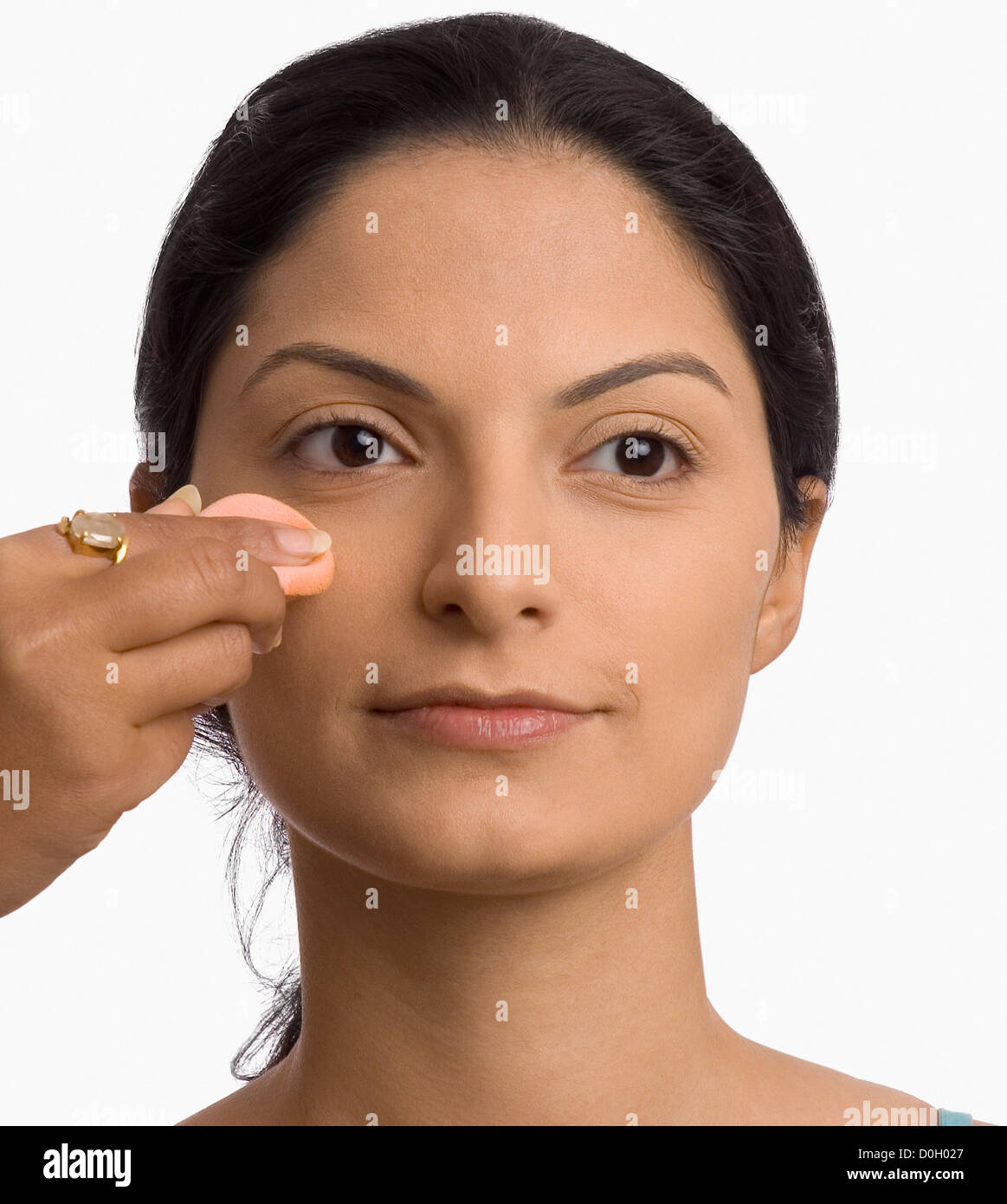 Person's hand applying powder puff on a young woman's face Stock Photo ...