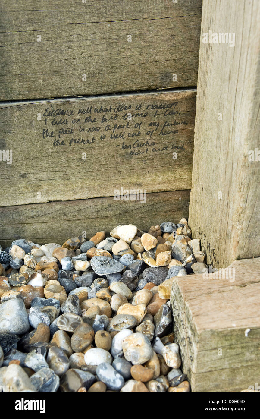Poem scribbled on to breakwater on seaside pebble beach Stock Photo - Alamy