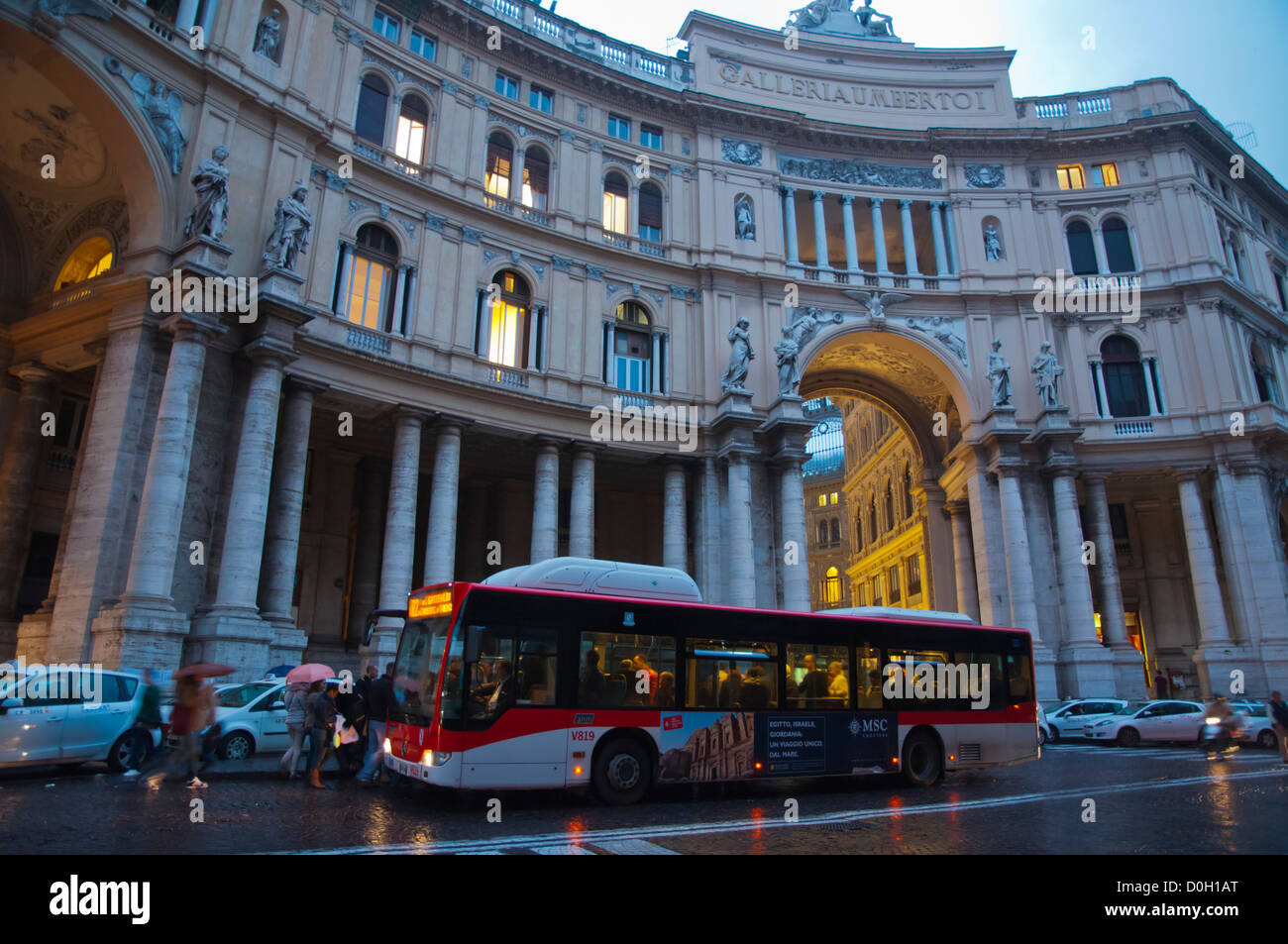 People getting into bus in rain outside Galleria Umberto I (1900 ...