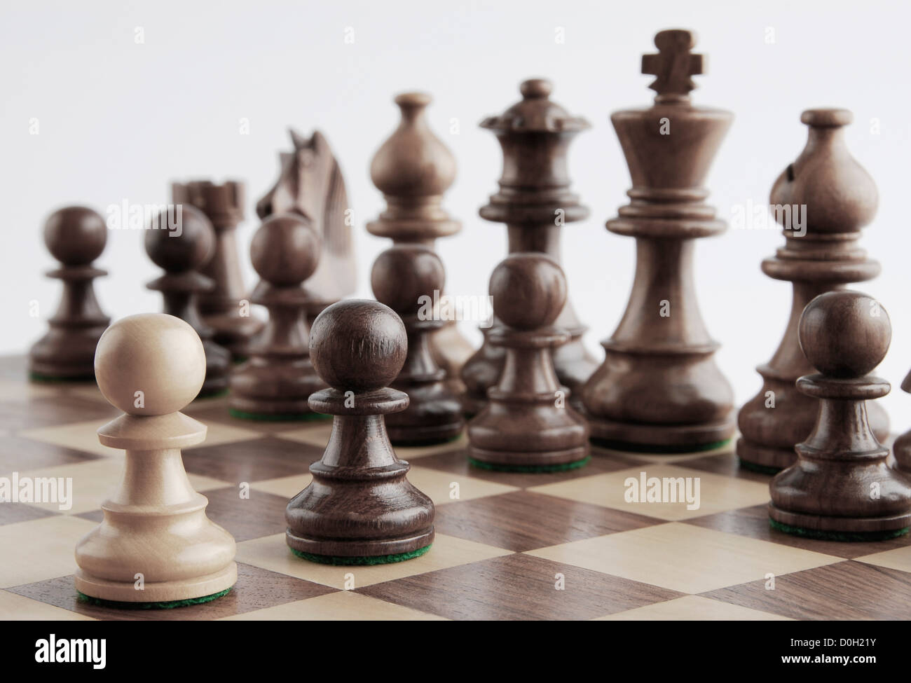 White pawn facing black chess pieces on a chess board Stock Photo - Alamy
