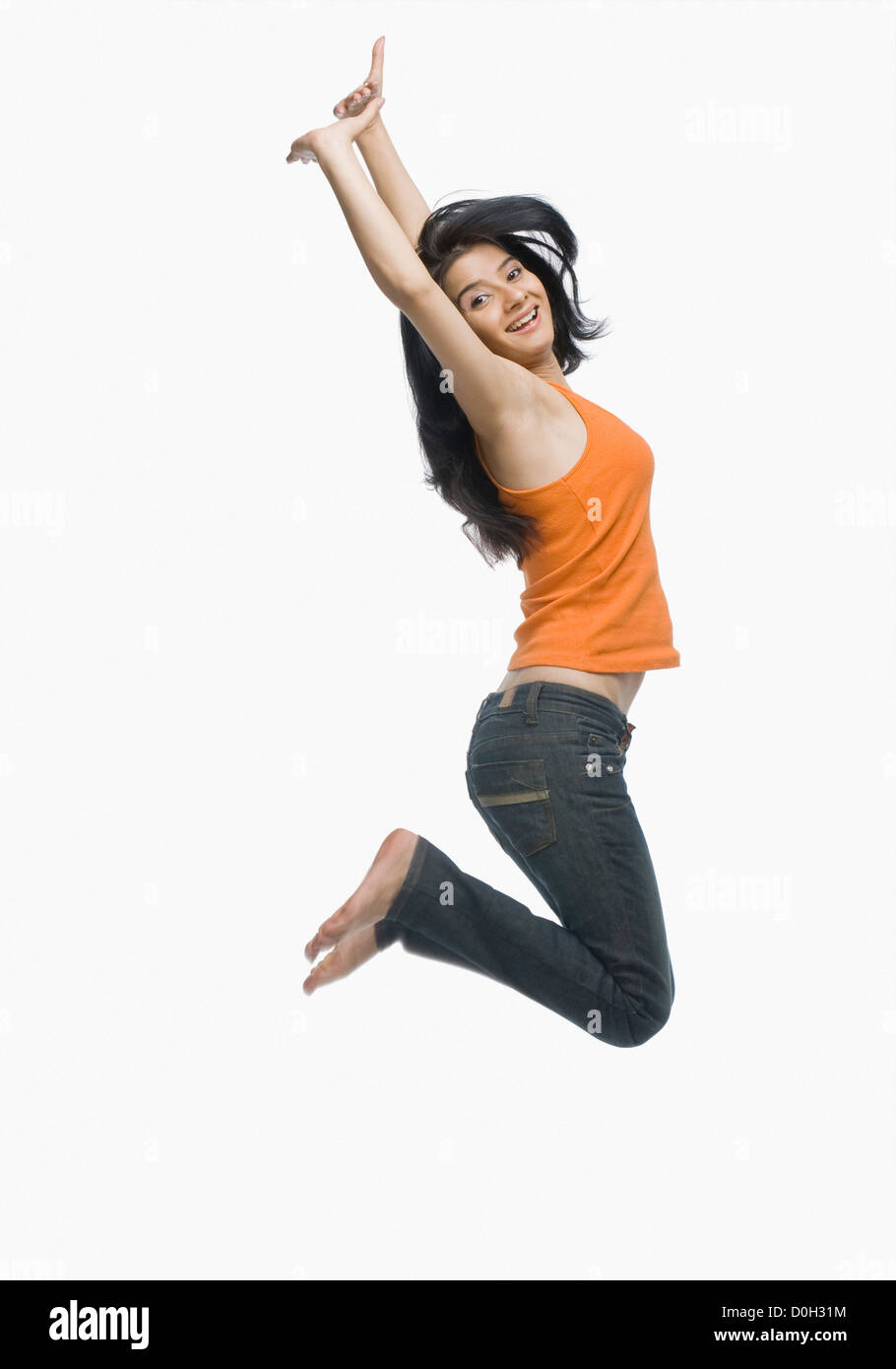 Young woman jumping against white background Stock Photo - Alamy