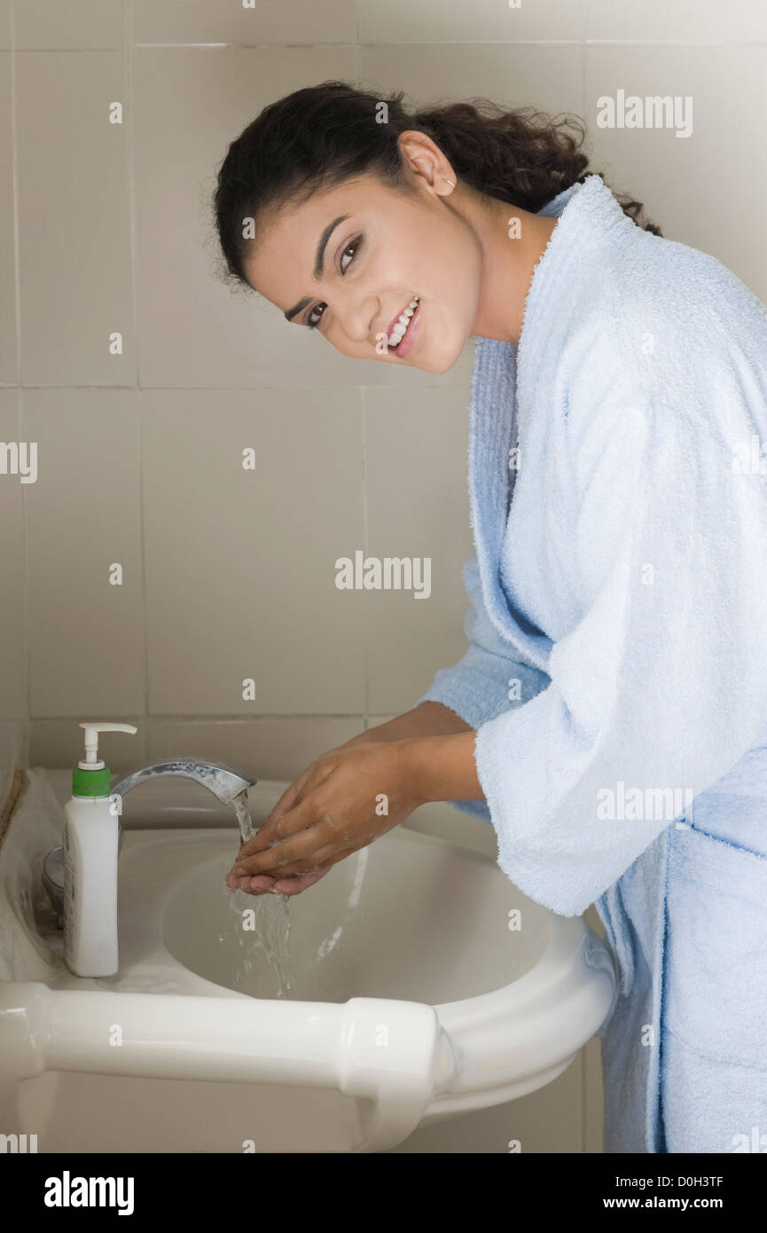 Young woman washing her hands Stock Photo - Alamy