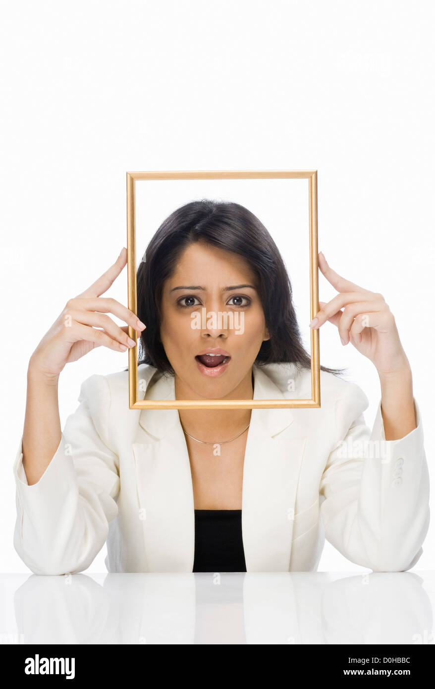 Businesswoman looking through a picture frame Stock Photo - Alamy