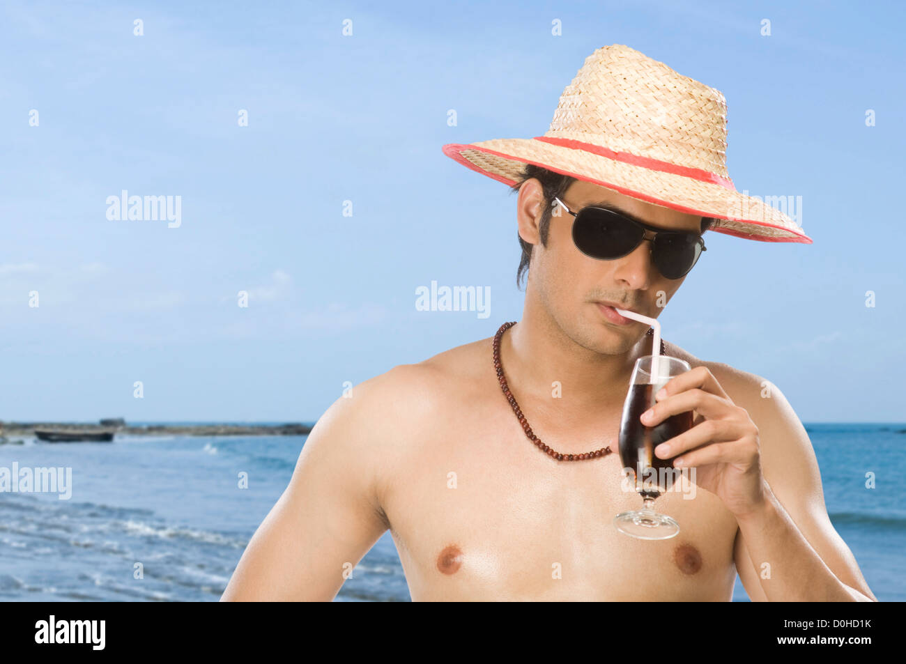 Close-up of a young man holding a glass of soft drink Stock Photo - Alamy