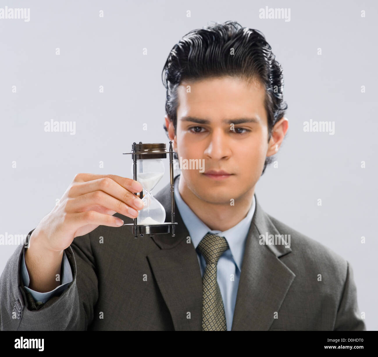 Businessman looking at an hourglass Stock Photo - Alamy