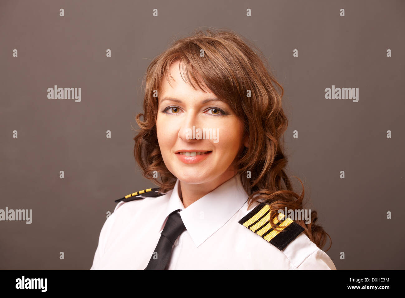 Beautiful woman pilot wearing uniform with epauletes looking ahead ...