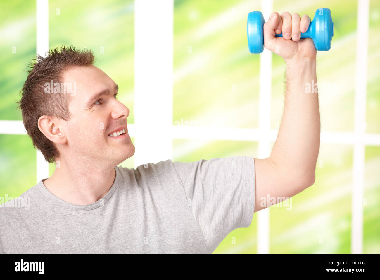 Portrait of happy man working with dumbbells Stock Photo - Alamy