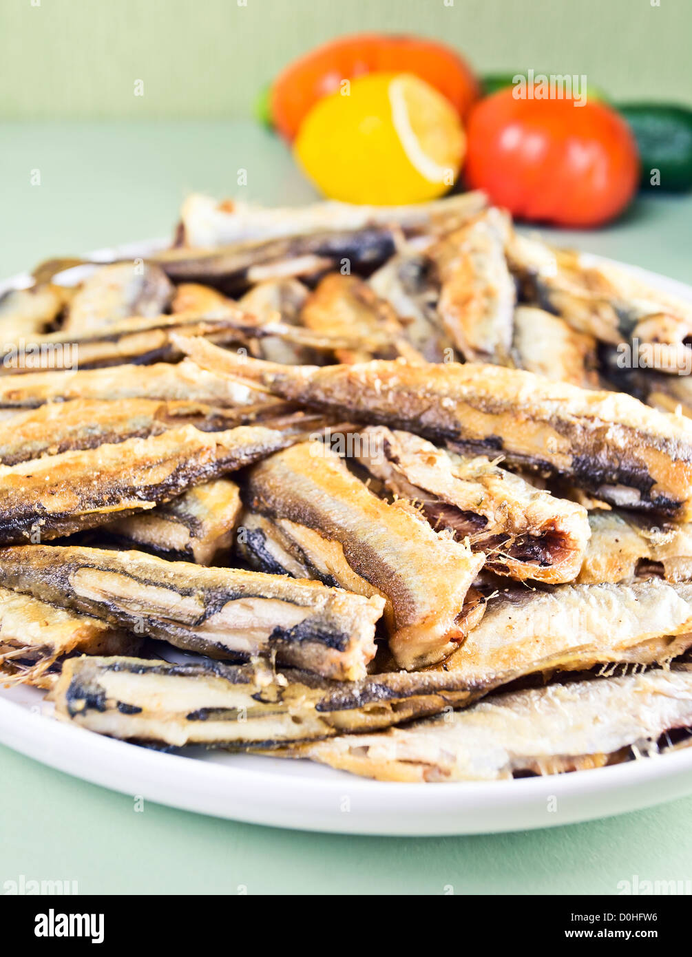 The fresh roasted anchovies on a white plate Stock Photo - Alamy