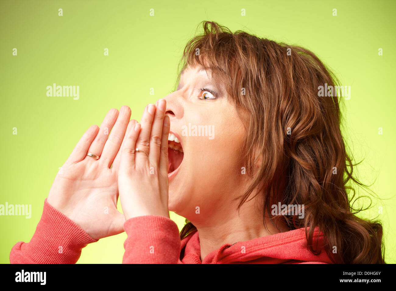 portrait of beautiful woman loud screaming or calling out to someone ...