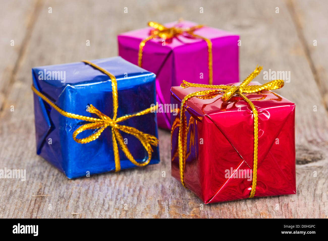three color gift boxes on the wooden floor Stock Photo - Alamy