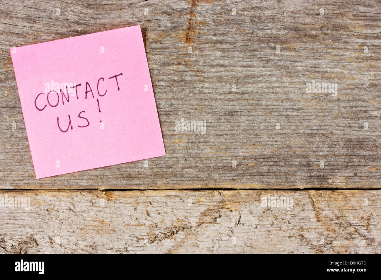 Red sticky note on a wooden wall with the words Contact Us on it Stock ...