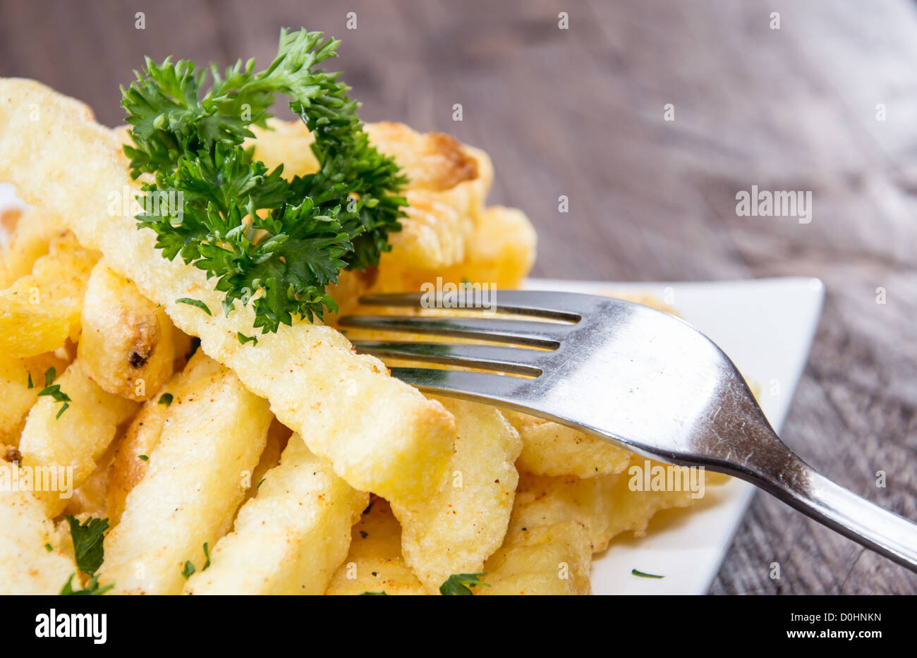 Plate with french fries on wooden background Stock Photo - Alamy