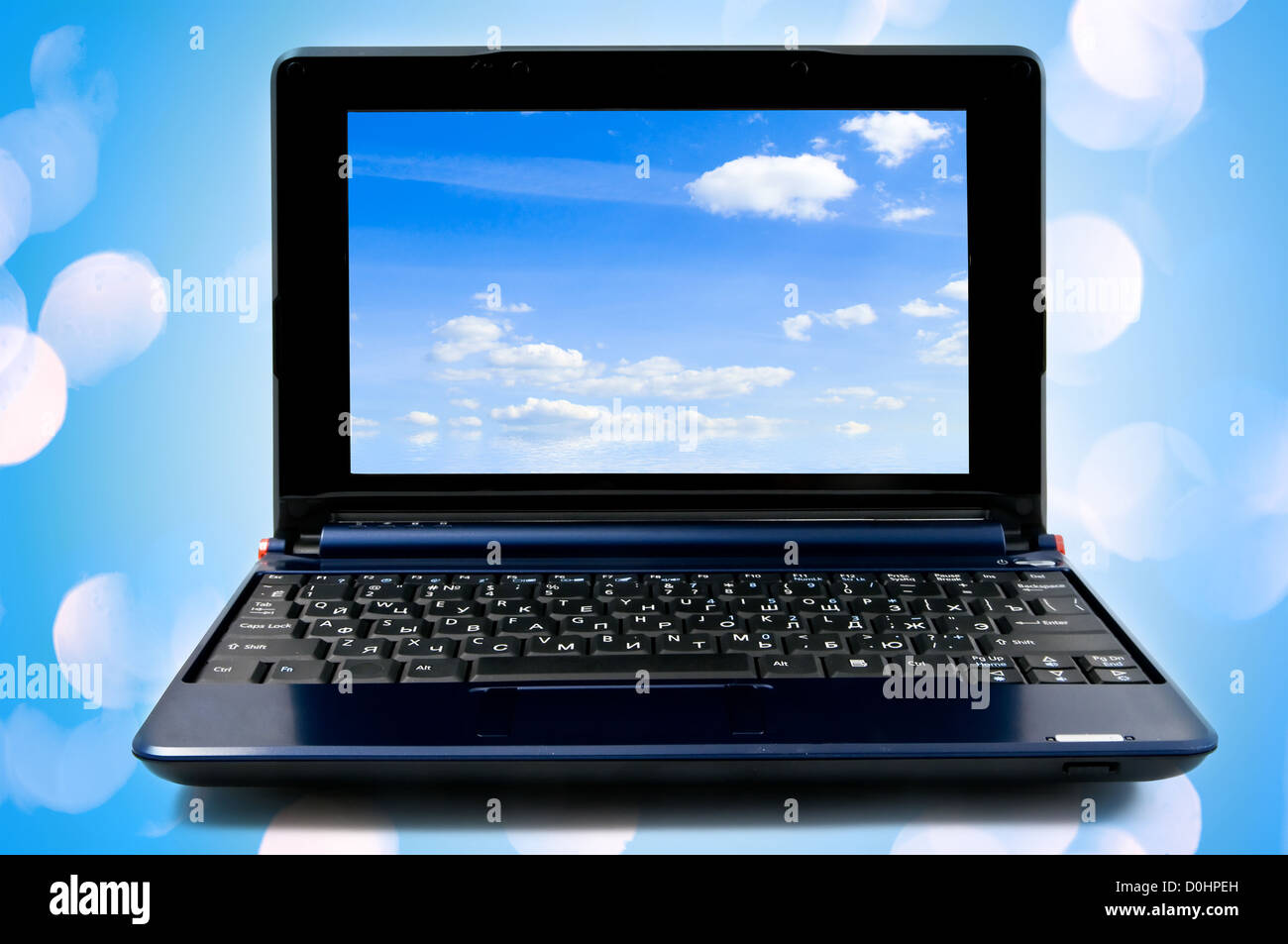 Modern and stylish laptop computer with blue cloudy sky wallpaper with ...