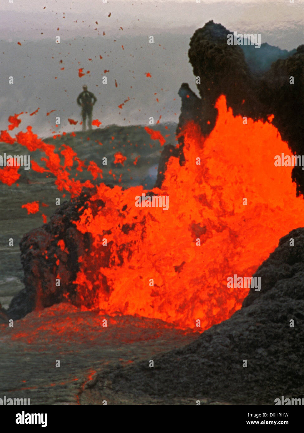 A Man Watches a Spatter Cone Erupting on Kilauea Volcano Stock Photo ...