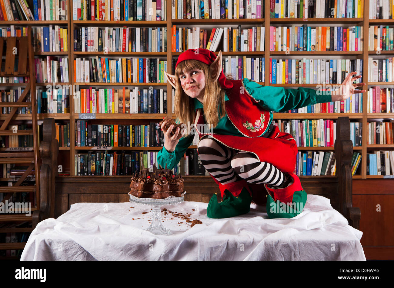 Elf character dressed in red and green Christmas outfit eating a ...