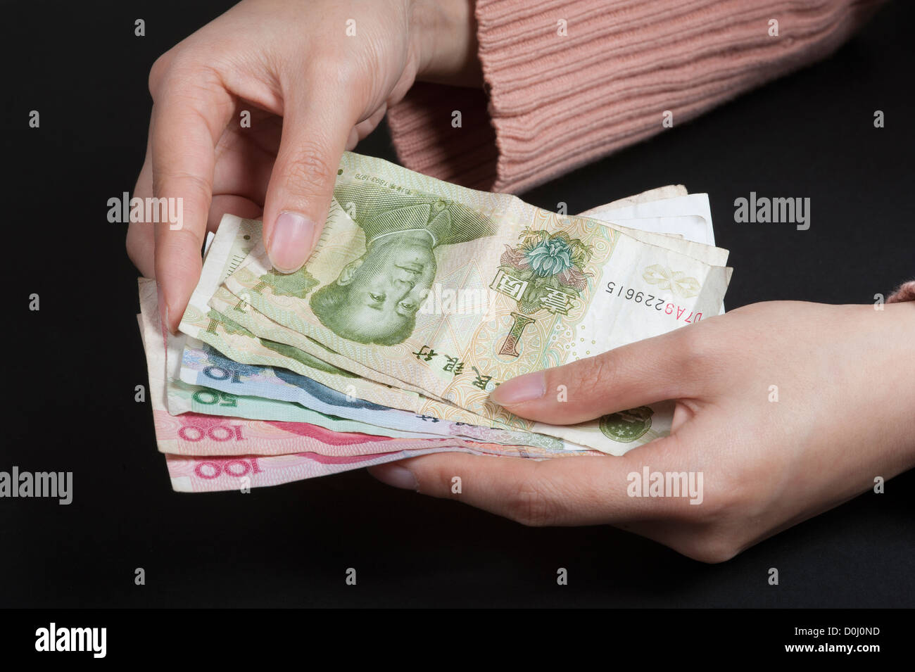 Female's hand holding Chinese Yuan banknotes Stock Photo - Alamy