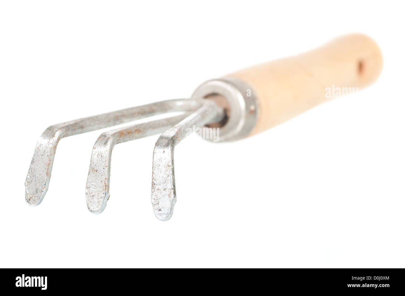 Old, rusty garden rake with a wooden handle over a white background ...