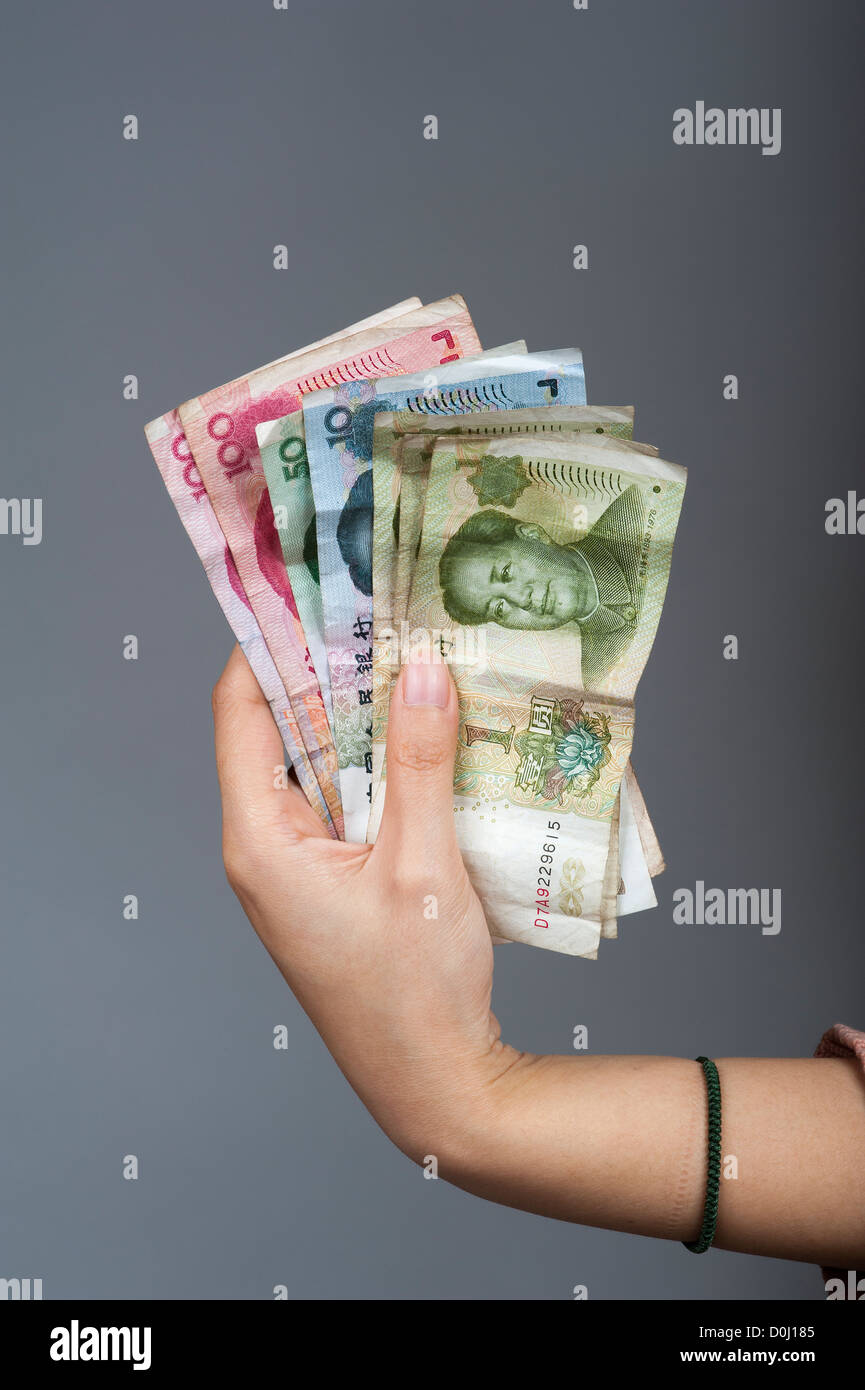 Female's hand holding Chinese Yuan banknotes Stock Photo - Alamy