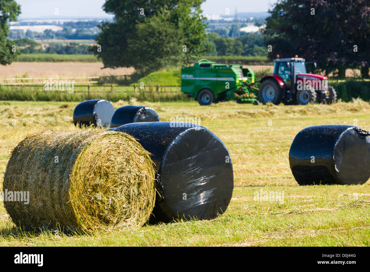 Tractor in field making hay bales Stock Photo - Alamy