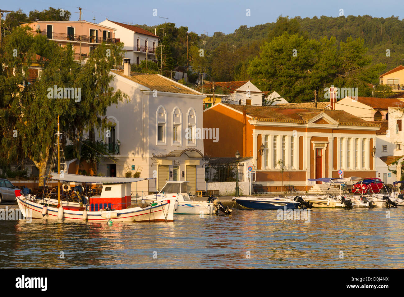 Fishing boat moored in front of classical buildings at Gaios harbour ...