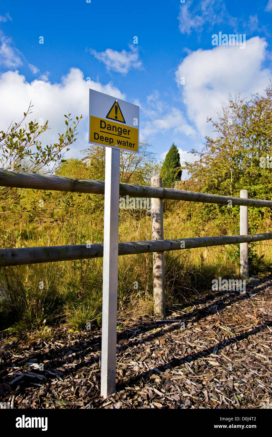 A "deep water" warning sign near to a small pond Stock Photo - Alamy