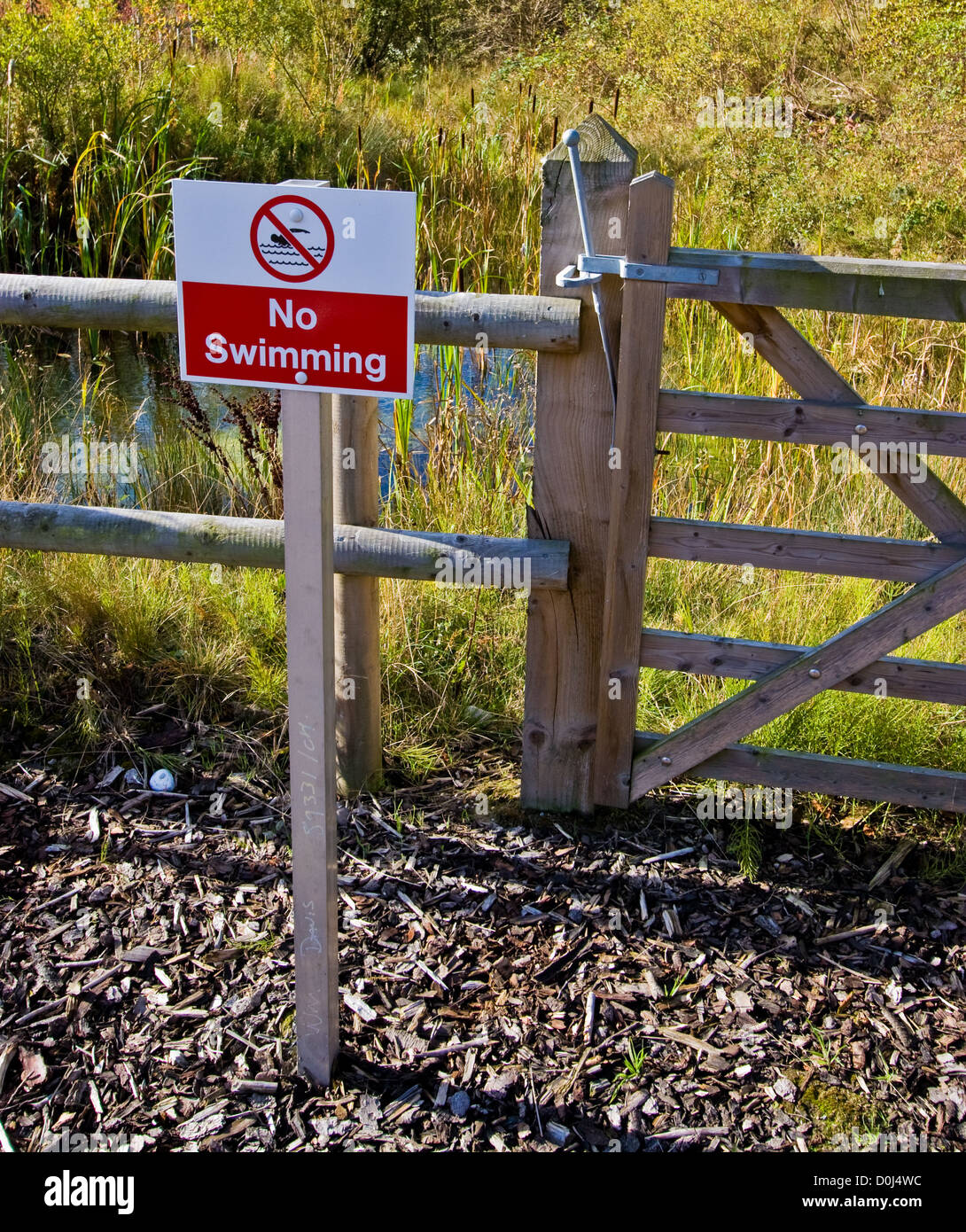 A "no swimming" warning sign near to a small pond Stock Photo - Alamy
