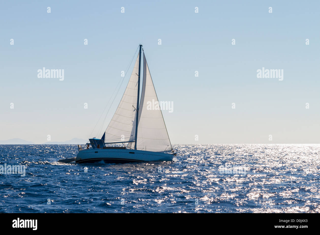 Yacht sailing in blue water Stock Photo - Alamy