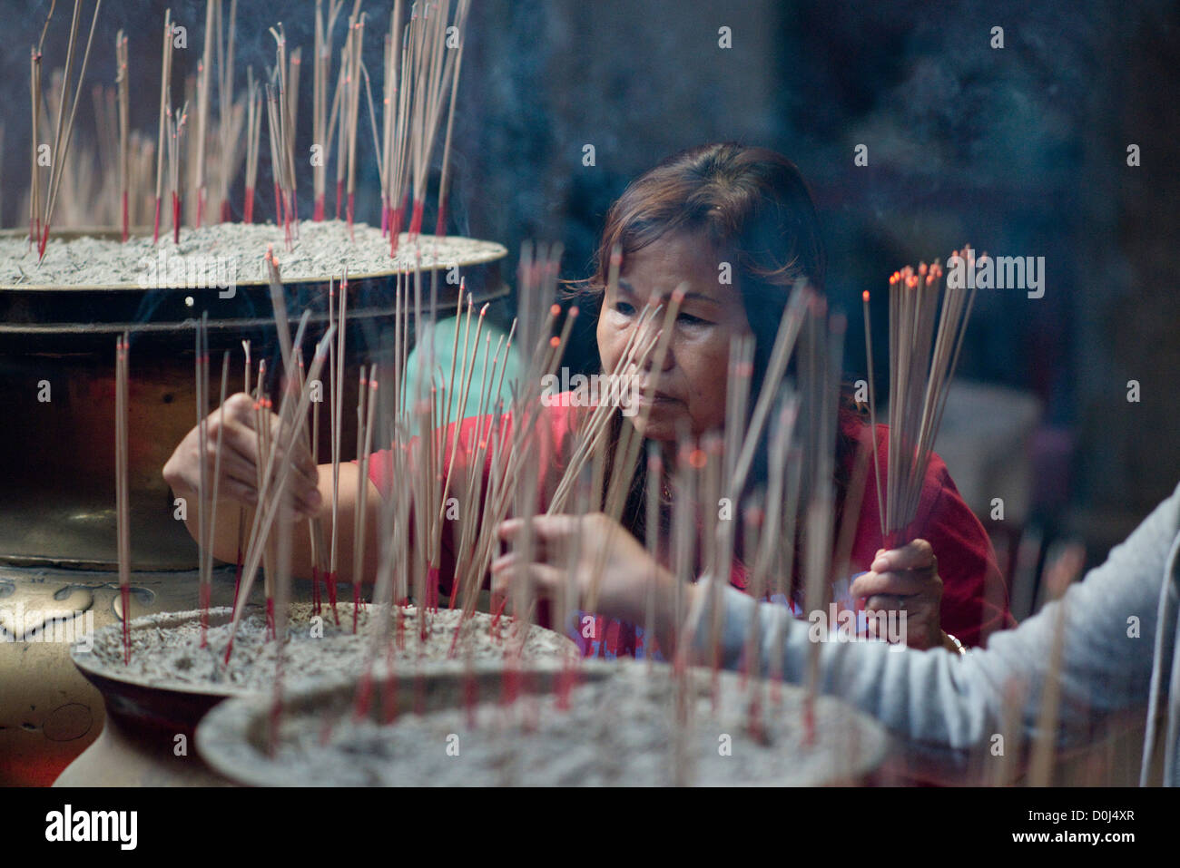 Tao Buddhist devotees place offerings of incense sticks at the Goddess ...